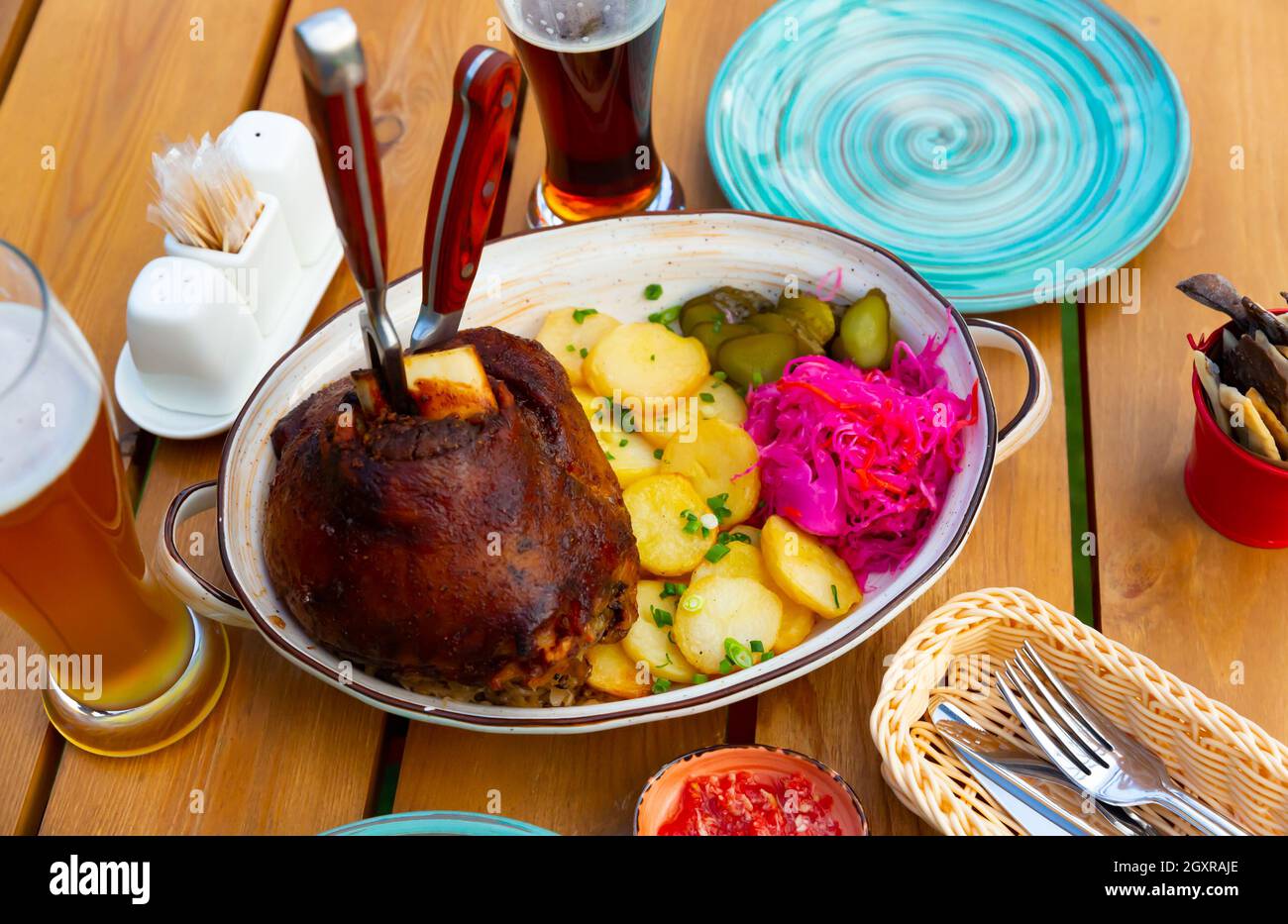 Roasted pork knuckle with potato and pickles Stock Photo - Alamy