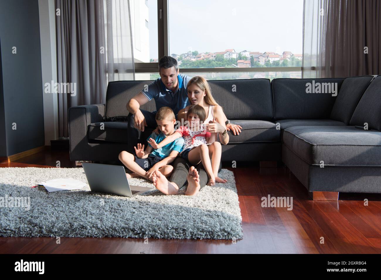 Happy Young Family Playing Together with laptop computer at home ...