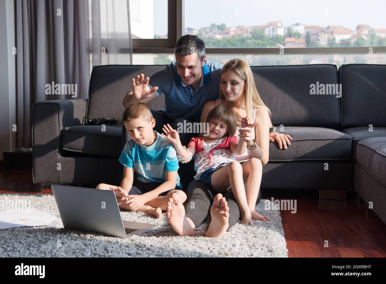 Happy Young Family Playing Together with laptop computer at home ...