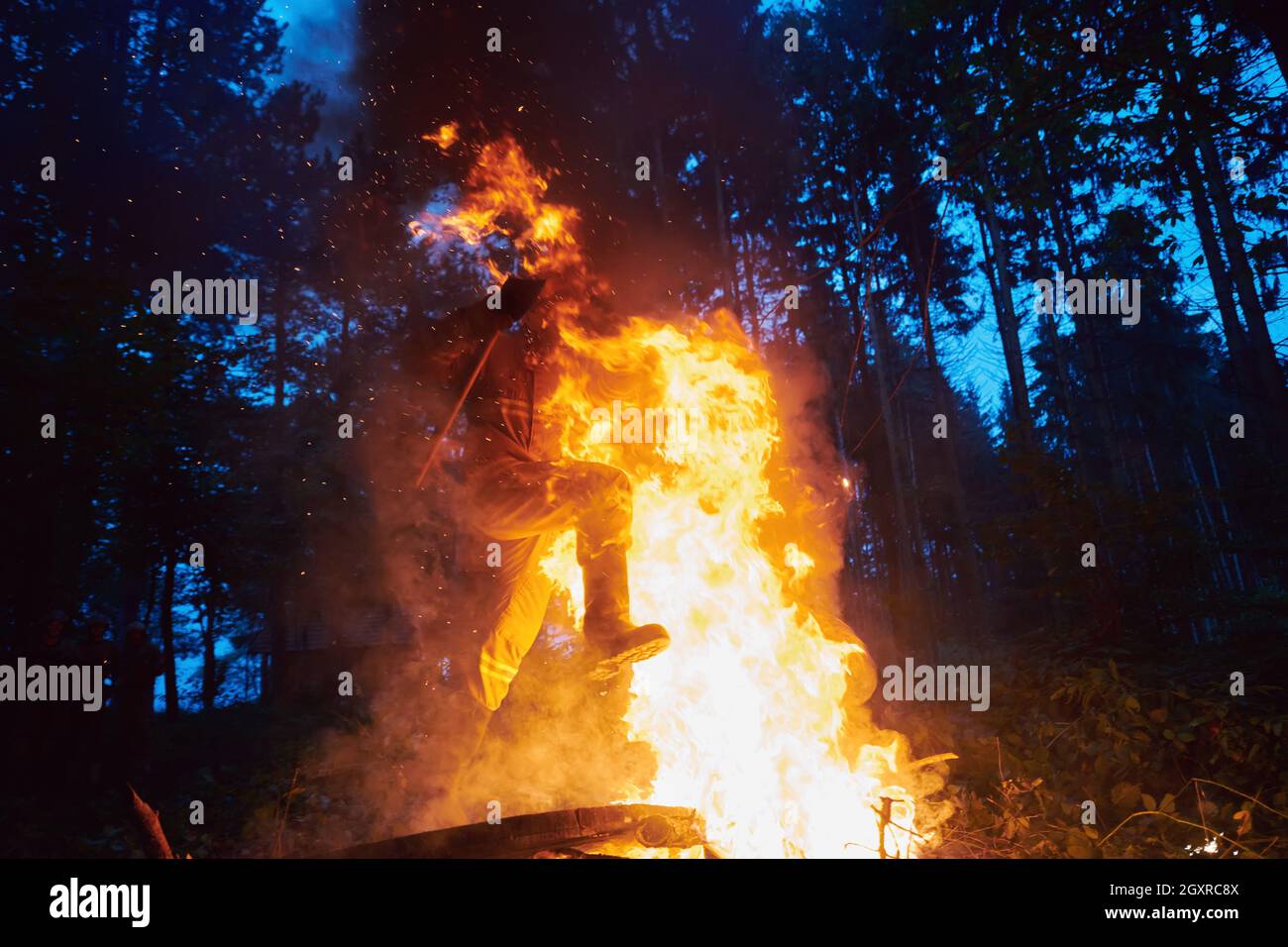 firefighter hero in action danger jumping over fire flame to rescue and ...