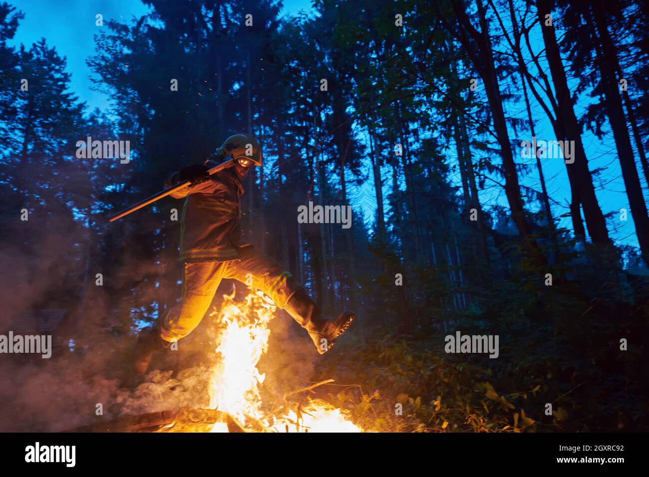 firefighter hero in action danger jumping over fire flame to rescue and ...