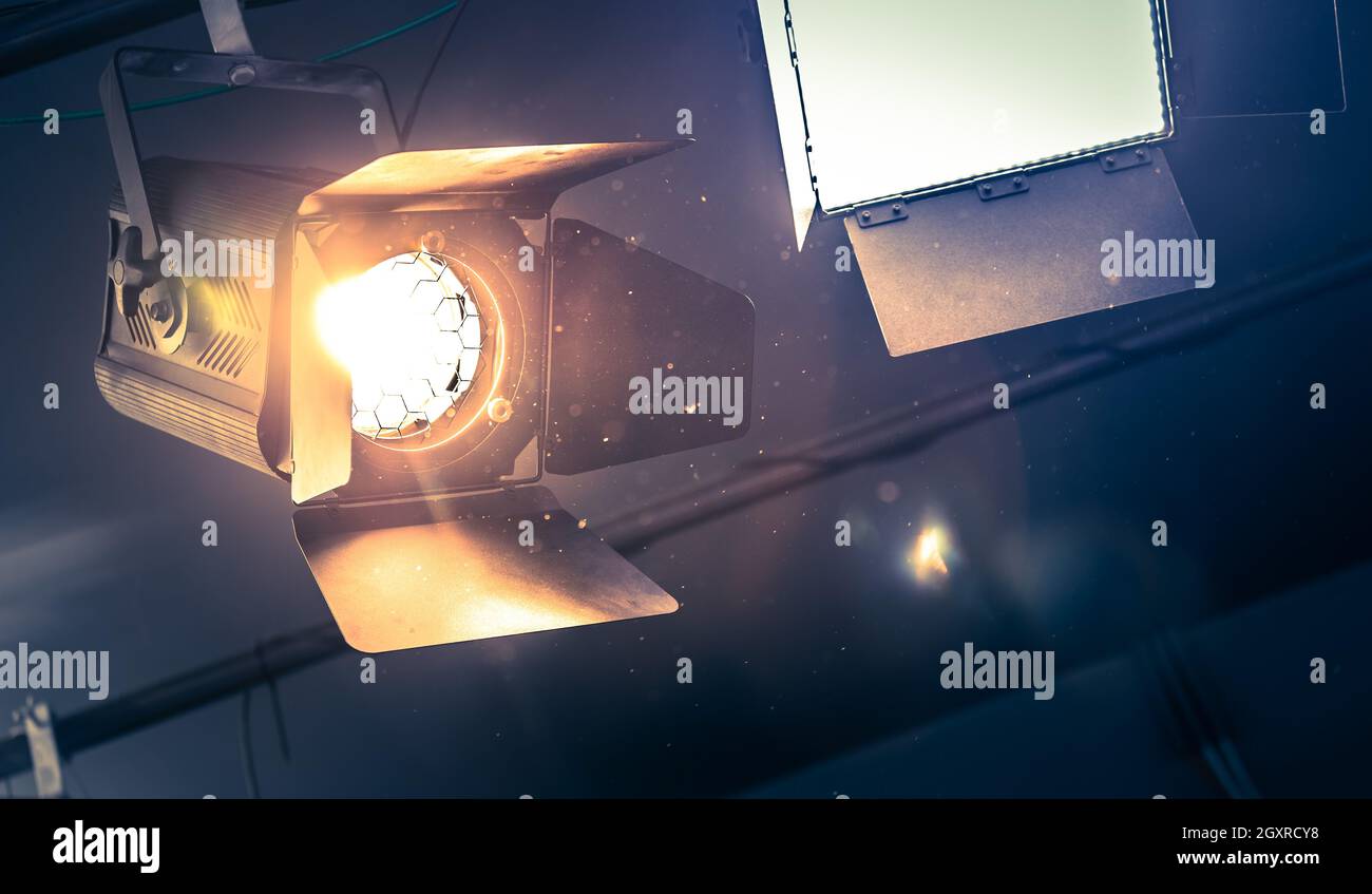 Professional orange studio spotlight hanging on the ceiling. Lighted ...