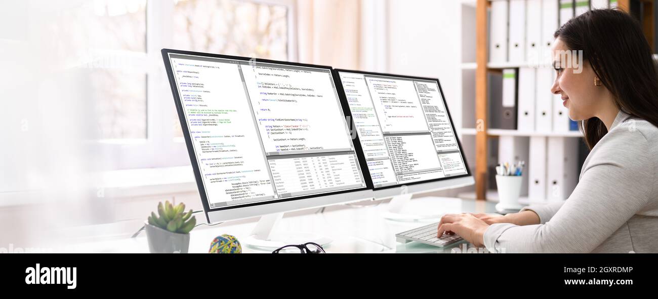 Coder Engineer Using Multiple Monitors At Desk Stock Photo - Alamy