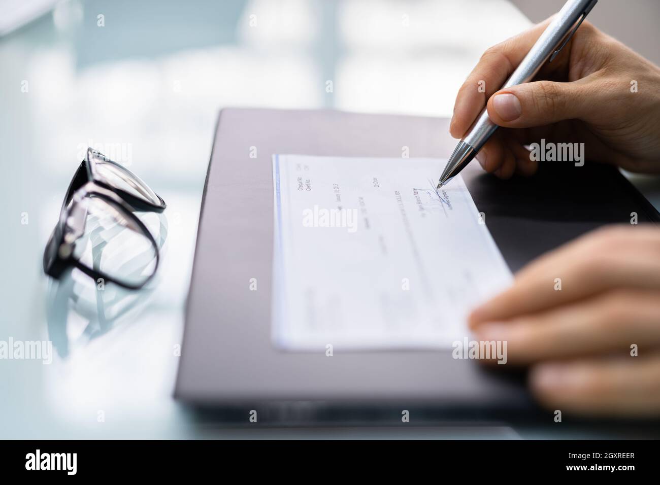 Hand Writing Payroll Cheque. Money Check Or Paycheck Stock Photo - Alamy