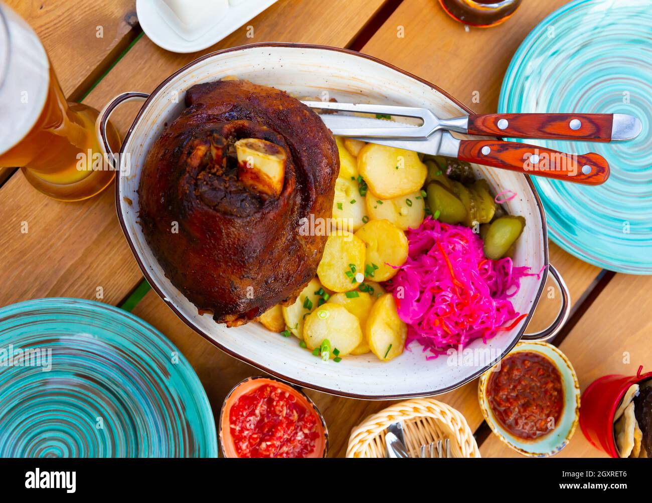 Roasted pork knuckle with potato and pickles Stock Photo - Alamy