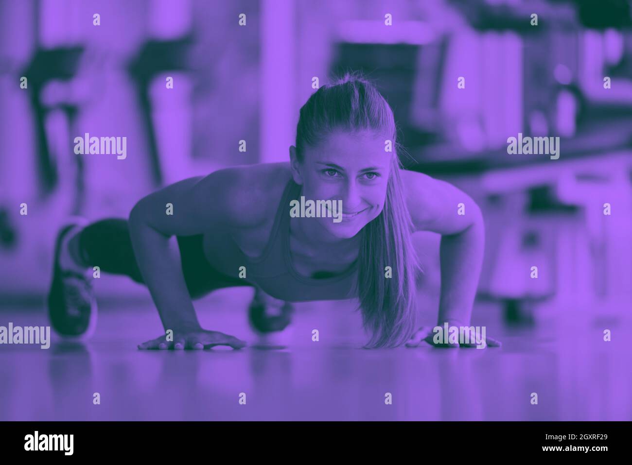 Gorgeous blonde woman warming up and doing some push ups a the gym duo ...