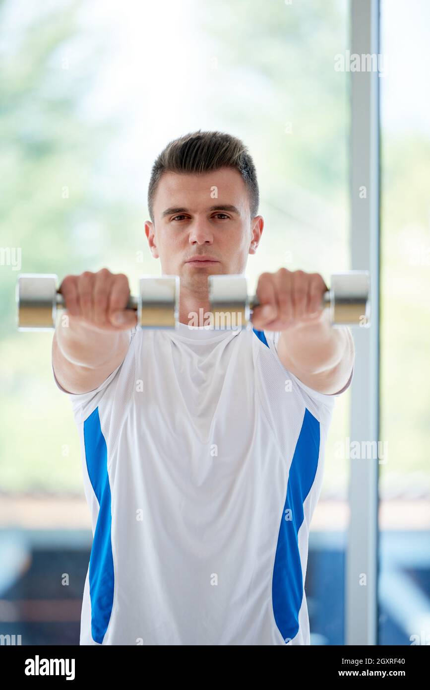 young man in fintess sport club exercise with weights and relaxing ...