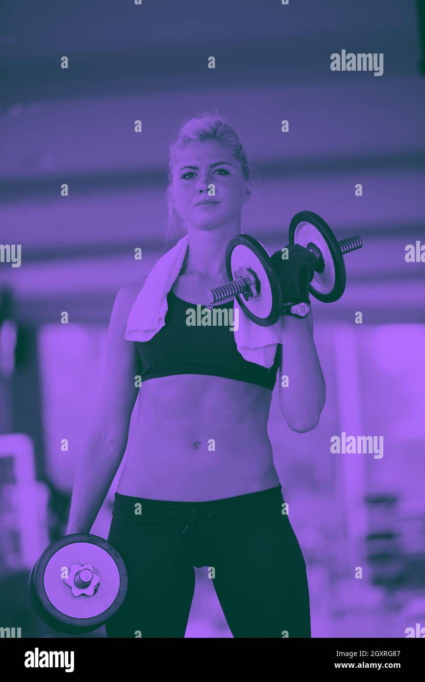 Gorgeou woman girl lifting some weights and working on her biceps in a ...