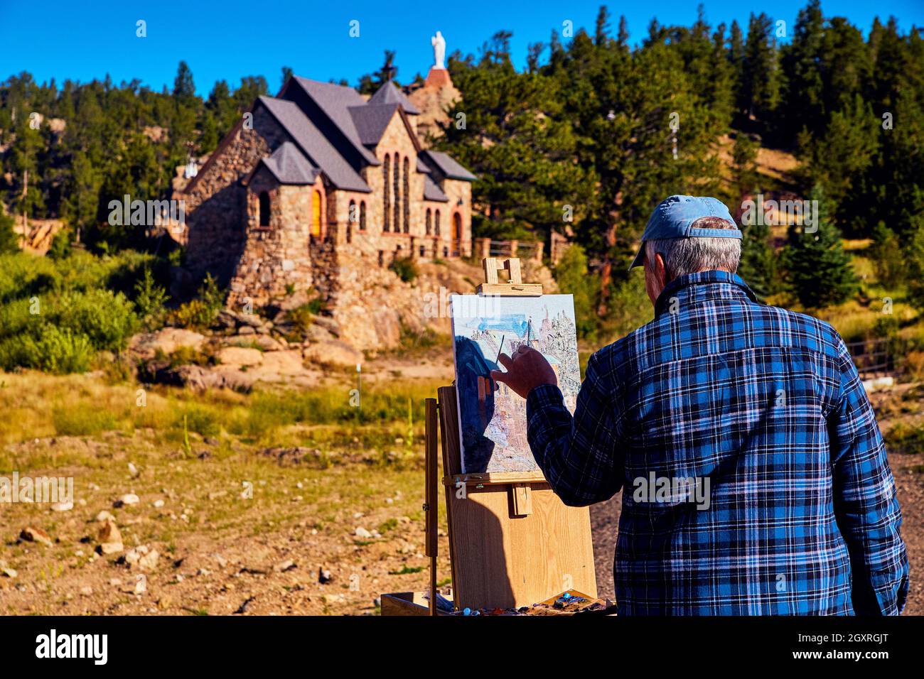 Back view of artist painting church outside in desert Stock Photo - Alamy