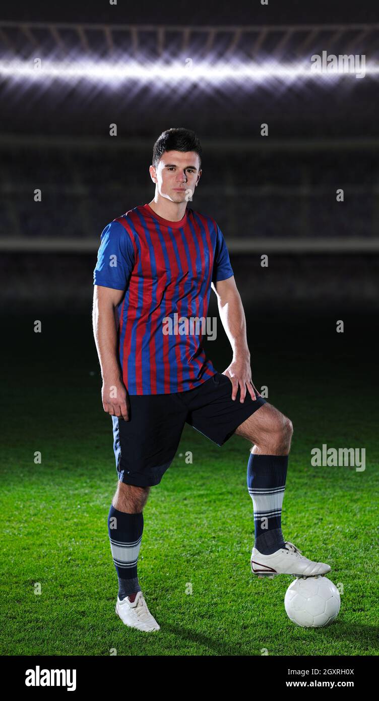 portrait of young handsome soccer player man at football stadium and ...