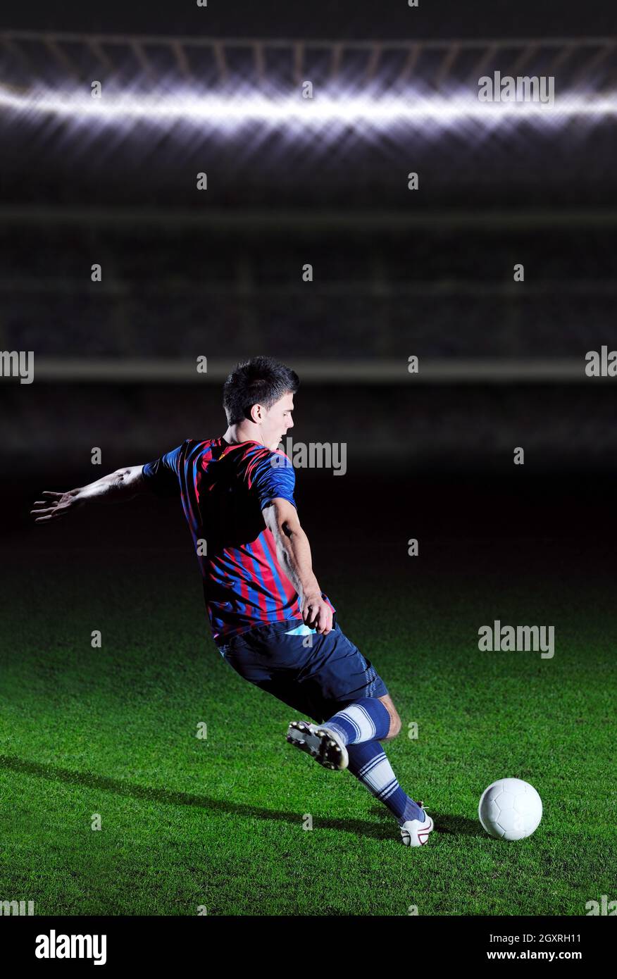 soccer player doing kick with ball on football stadium field isolated ...