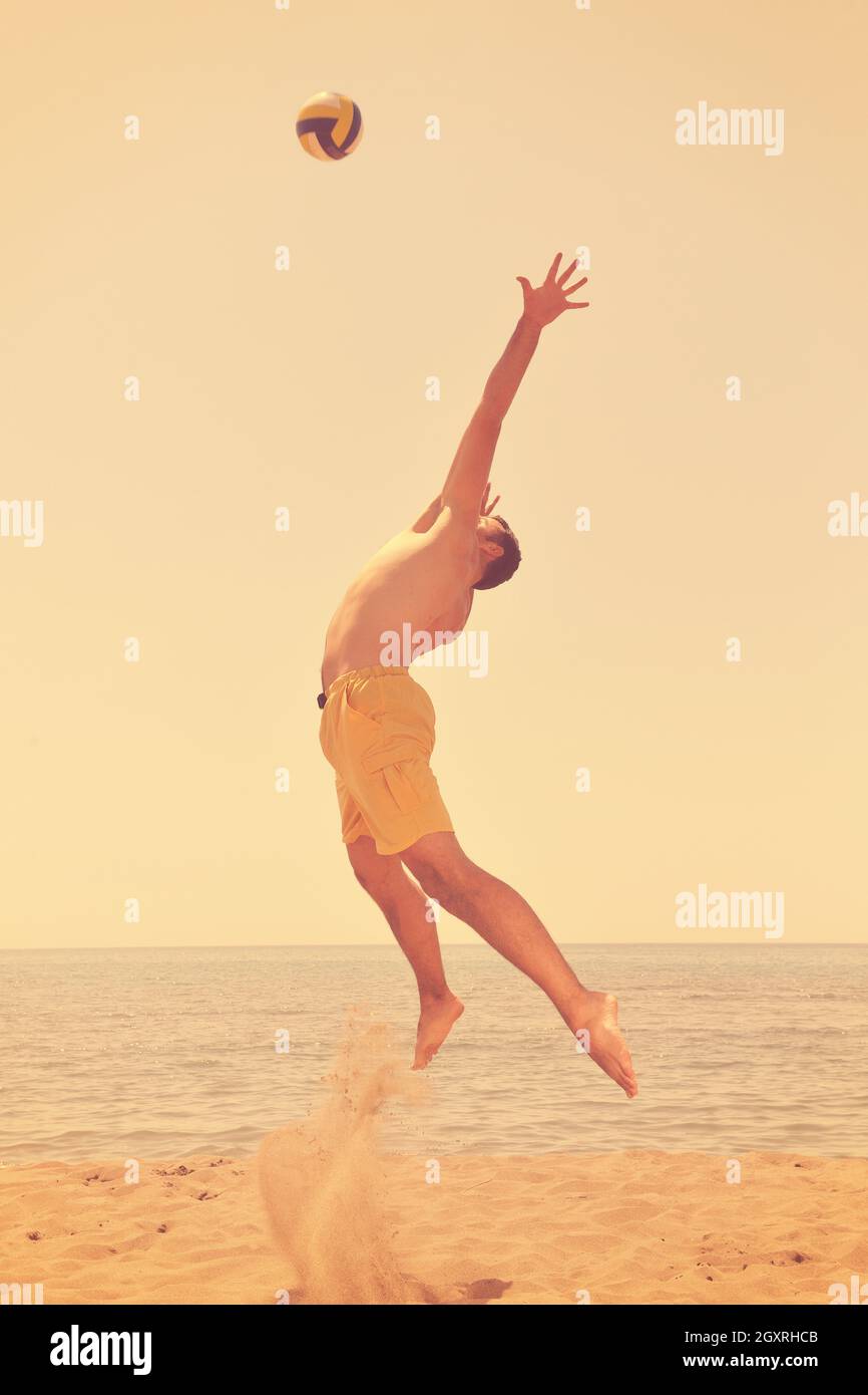 male beach volleyball game player jump on hot sand Stock Photo - Alamy