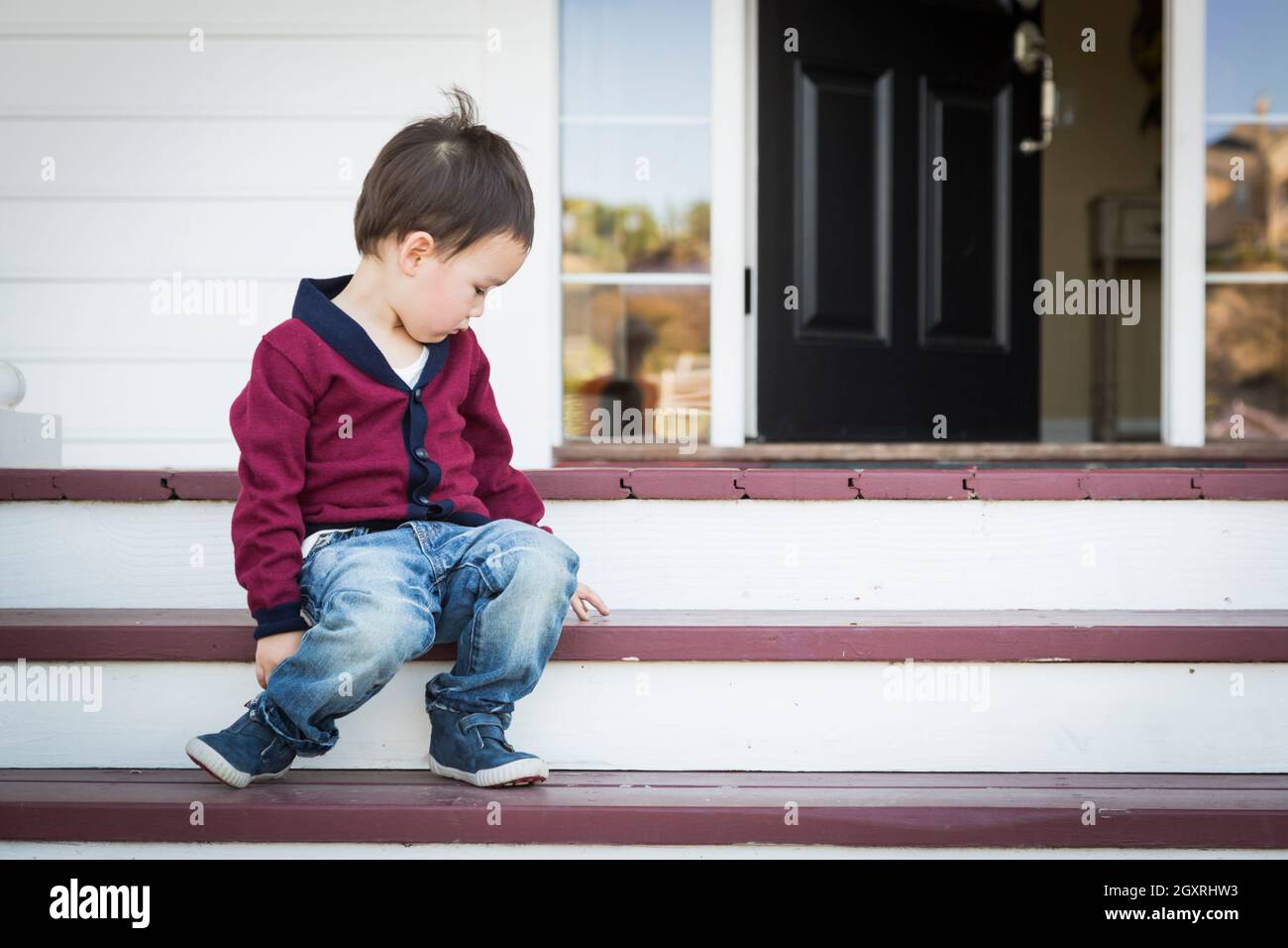 Cute Melancholy Mixed Race Boy Sitting on Front Porch Steps Stock Photo ...