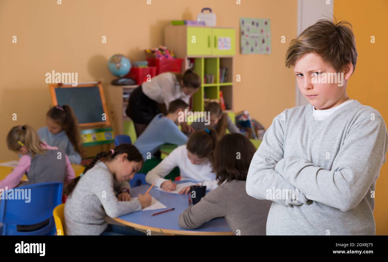 Unhappy schoolboy standing at class, children drawing Stock Photo - Alamy