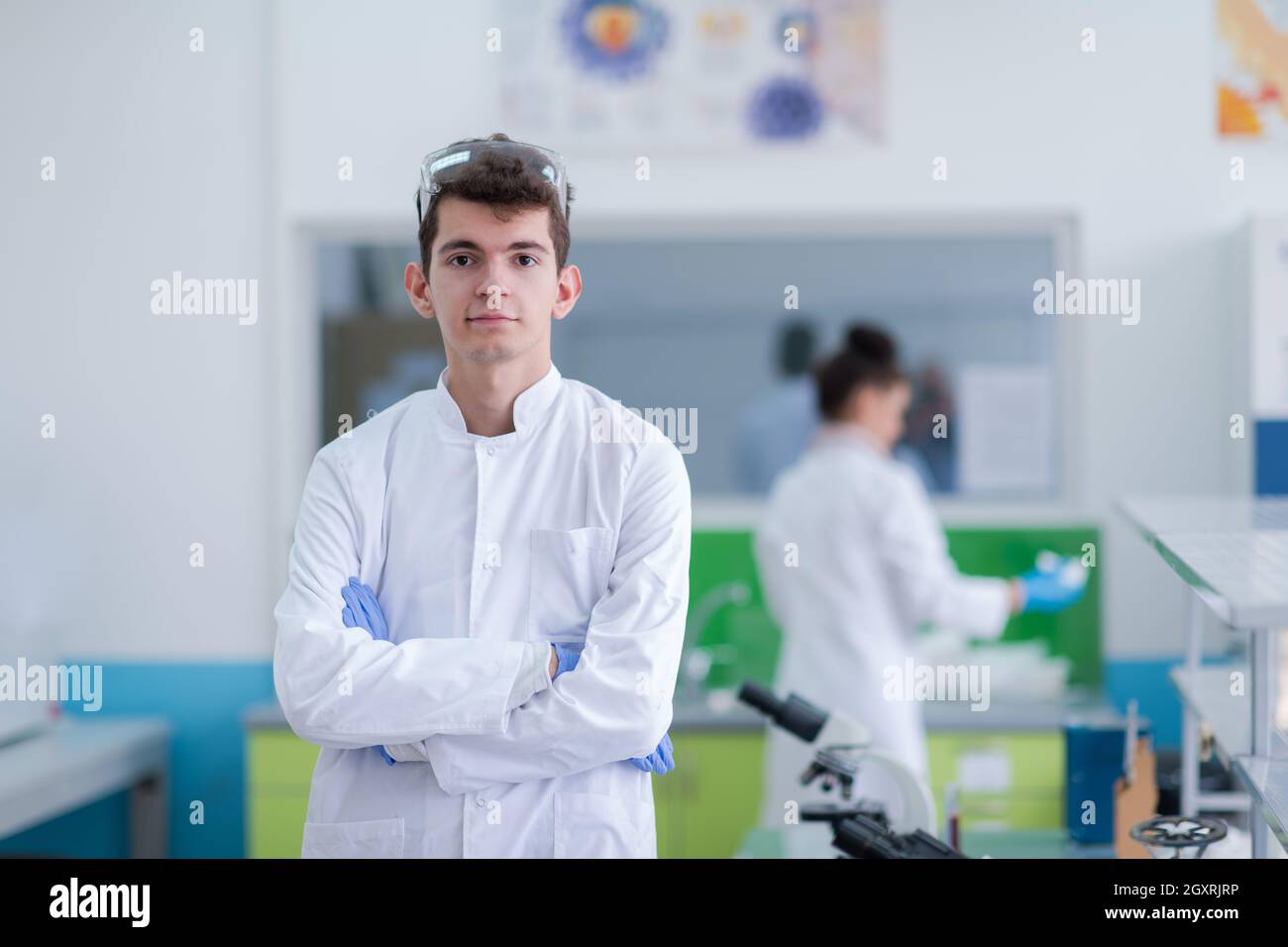 portrait of medical student in white coat while standing in chemistry ...