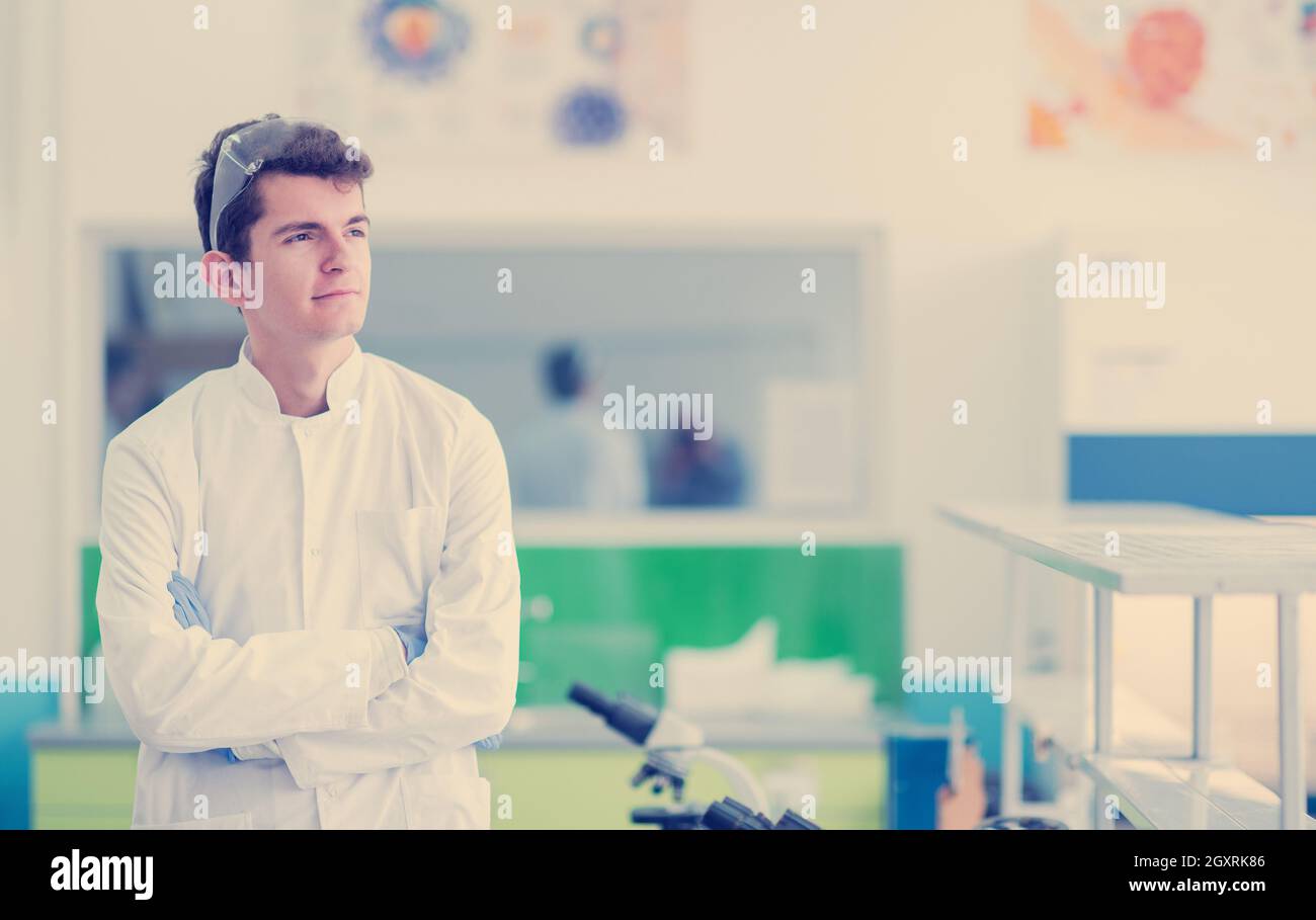 portrait of medical student in white coat while standing in chemistry ...
