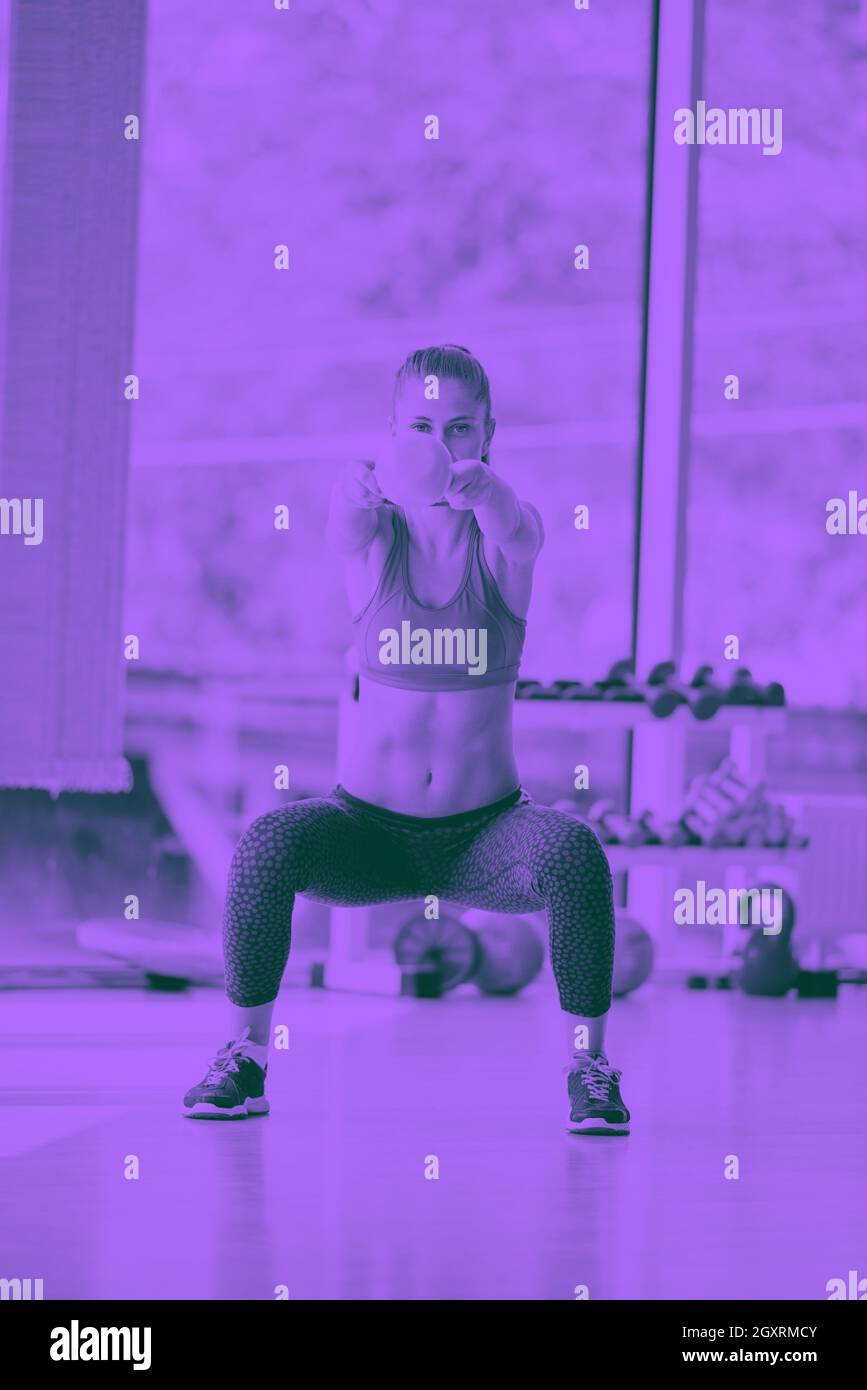 Gorgeou woman girl lifting some weights and working on her biceps in a ...