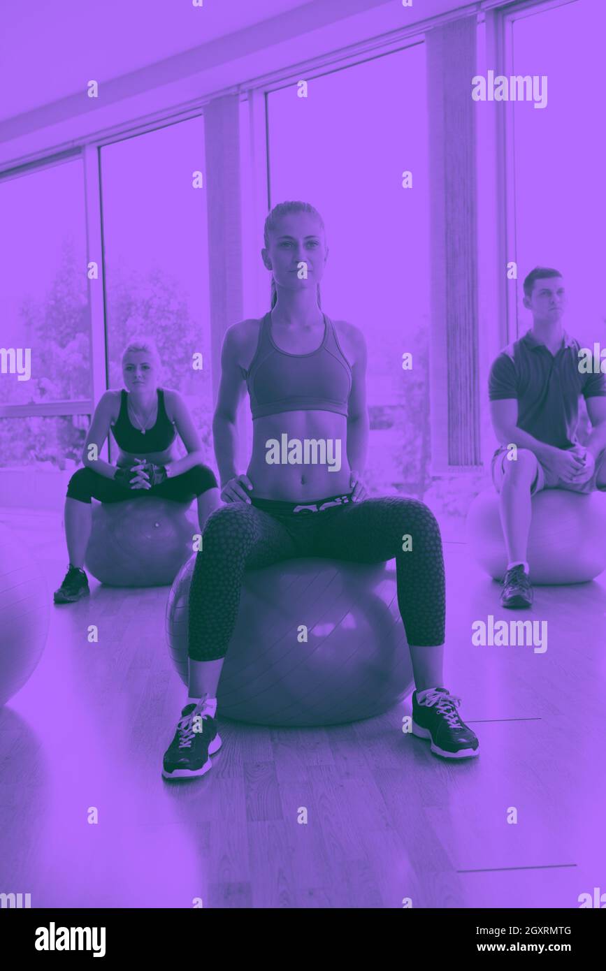 group of people exercise with balls on yoga class in fitness gym duo ...