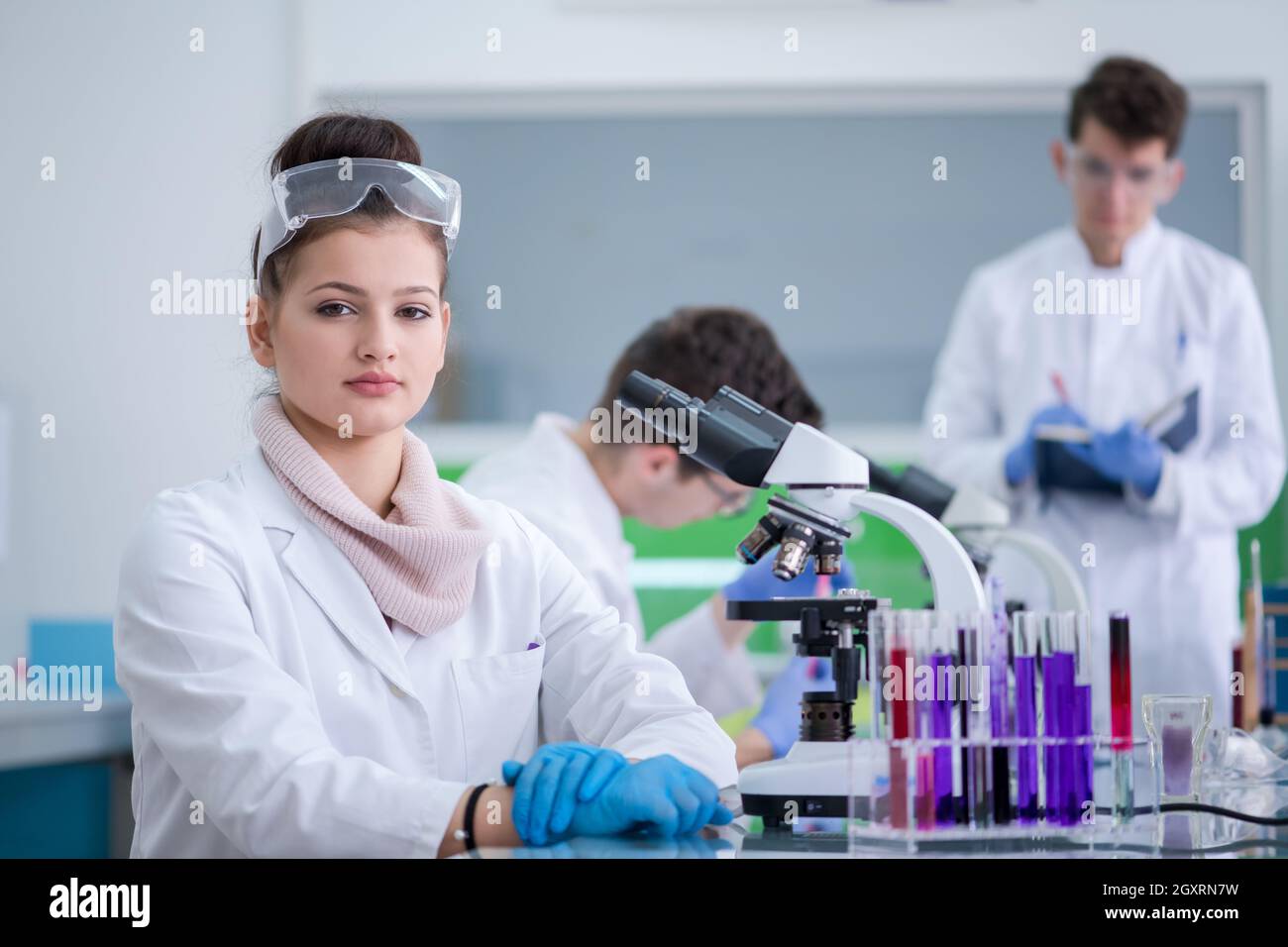 Group of young medical students doing research together in chemistry ...