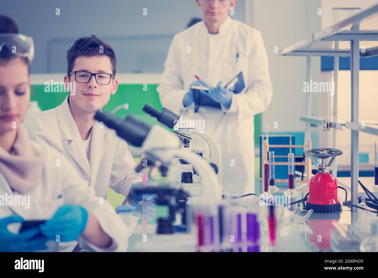 Group of young medical students doing research together in chemistry ...