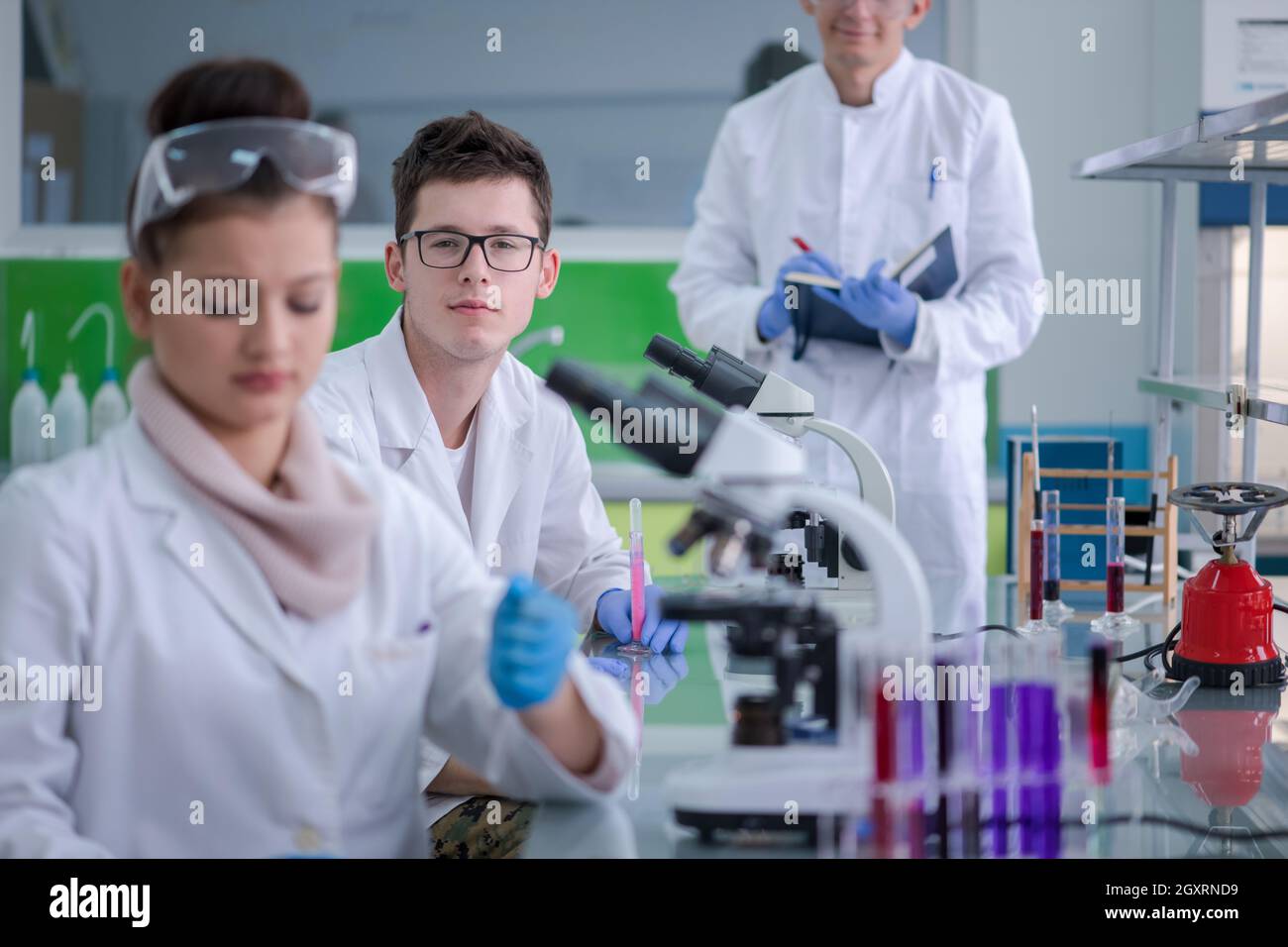 Group of young medical students doing research together in chemistry ...