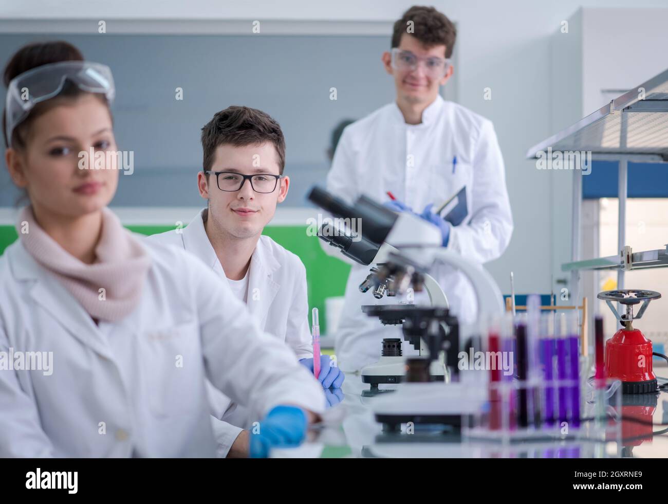 Group of young medical students doing research together in chemistry ...