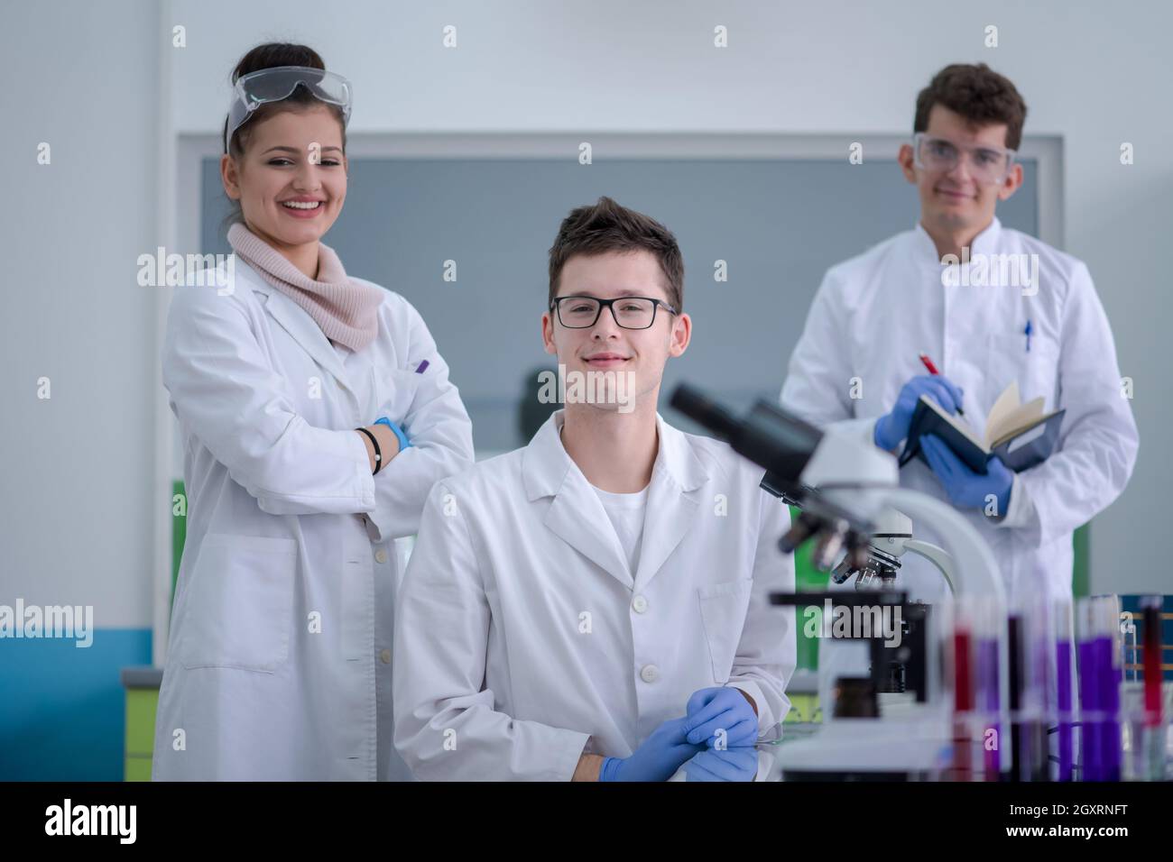 Group of young medical students doing research together in chemistry ...