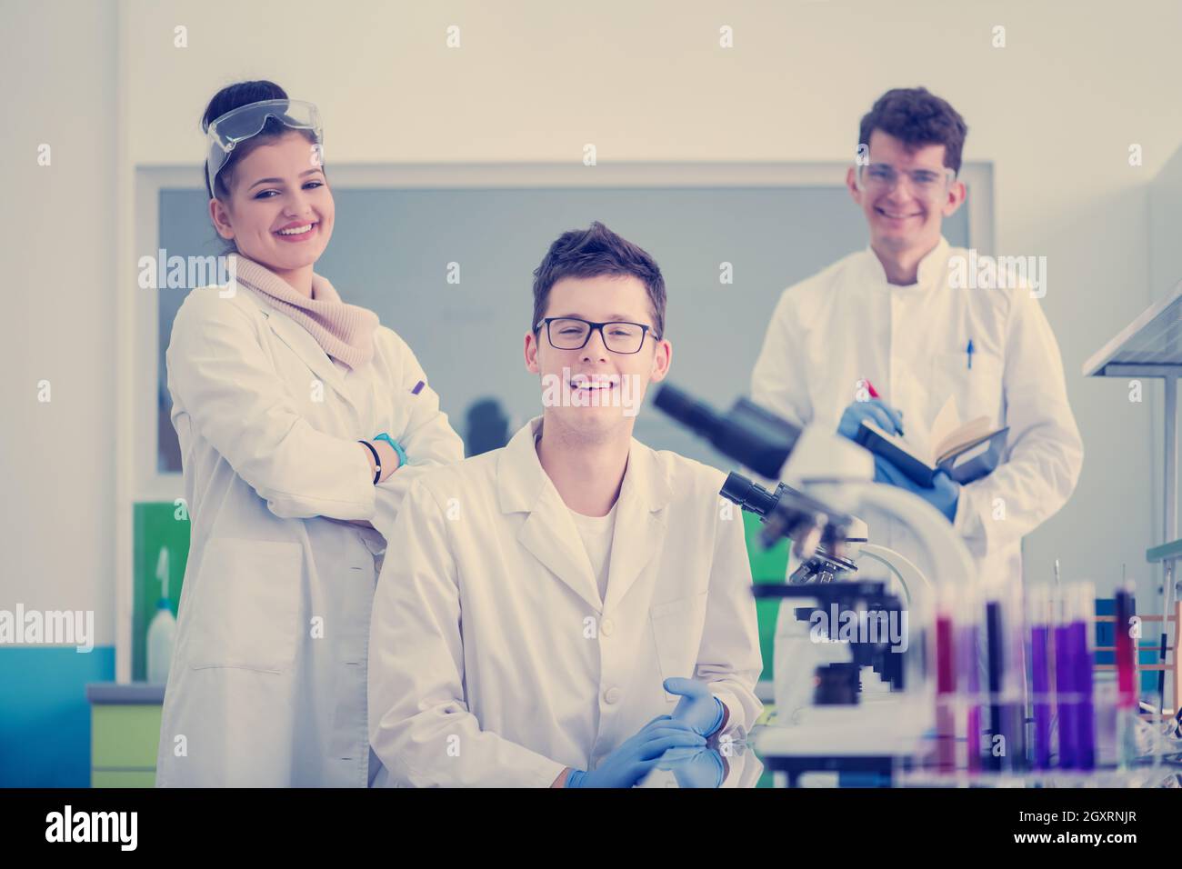 Group of young medical students doing research together in chemistry ...