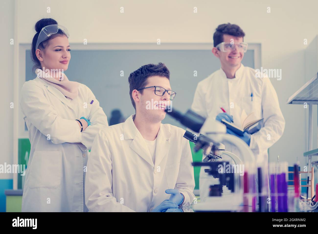 Group of young medical students doing research together in chemistry ...