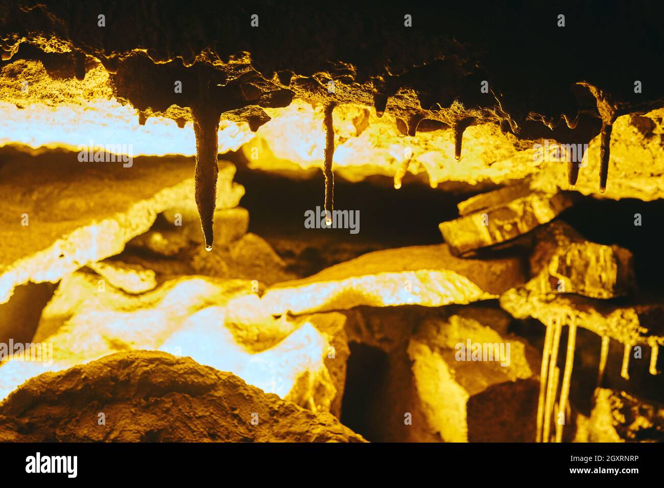 Close up detail of cave formation stalactites with water on tips ...