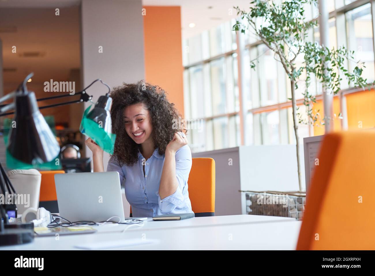 happy young business woman with curly hairstyle in the modern office ...