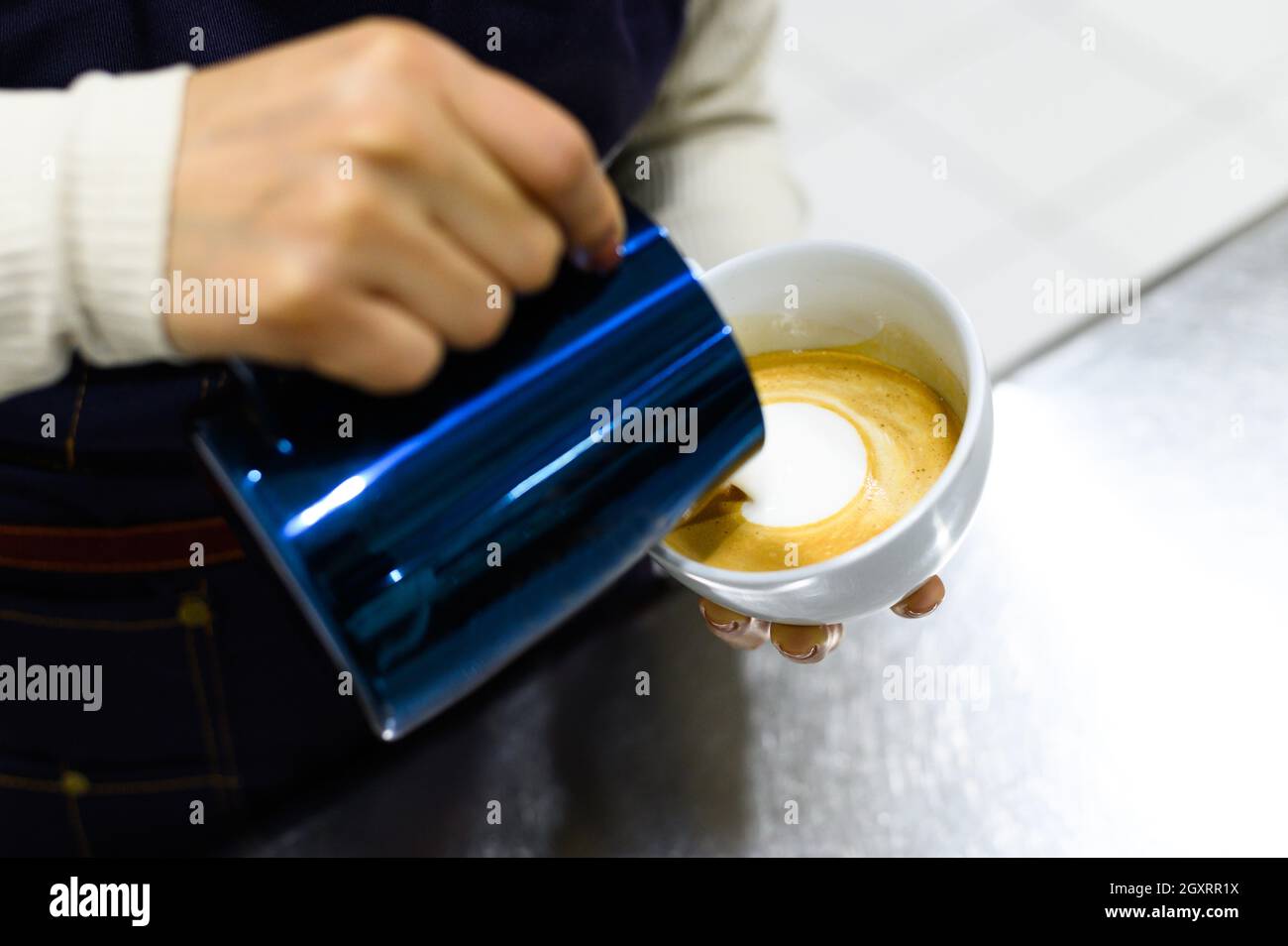 Hands of barista making latte or cappuccino coffee pouring milk, making ...