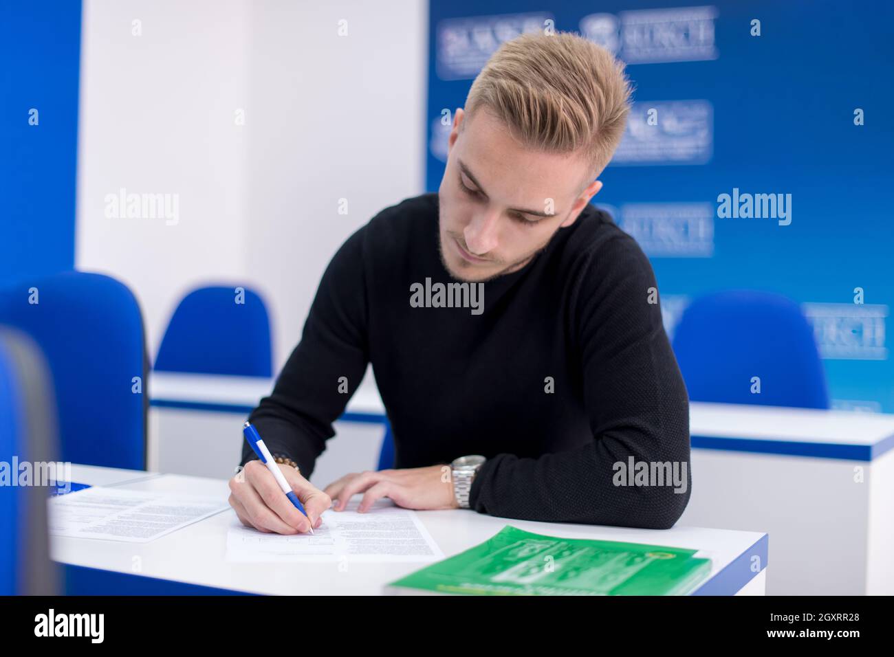young male student writing notes in the classroom Stock Photo - Alamy