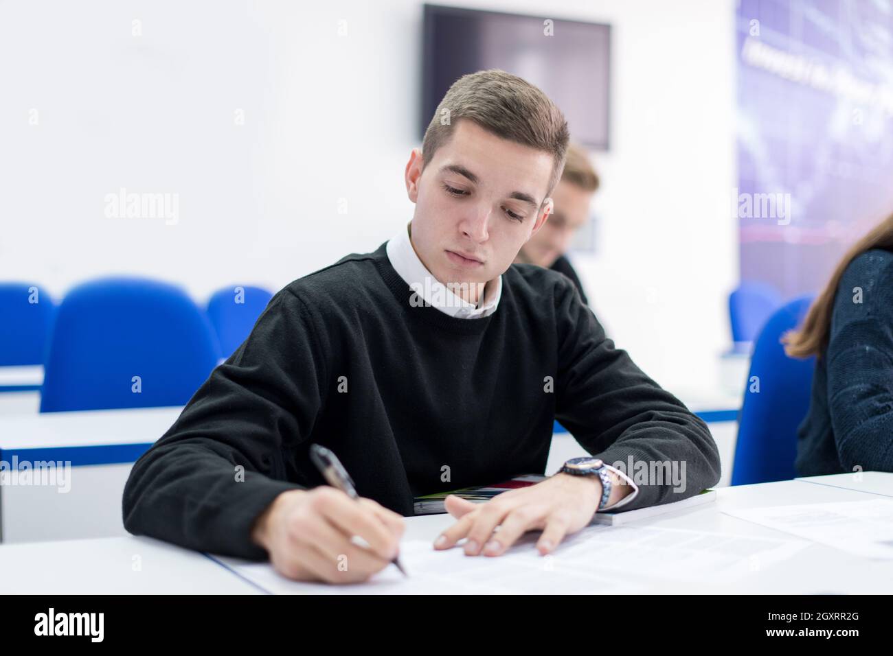 young male student writing notes in the classroom Stock Photo - Alamy