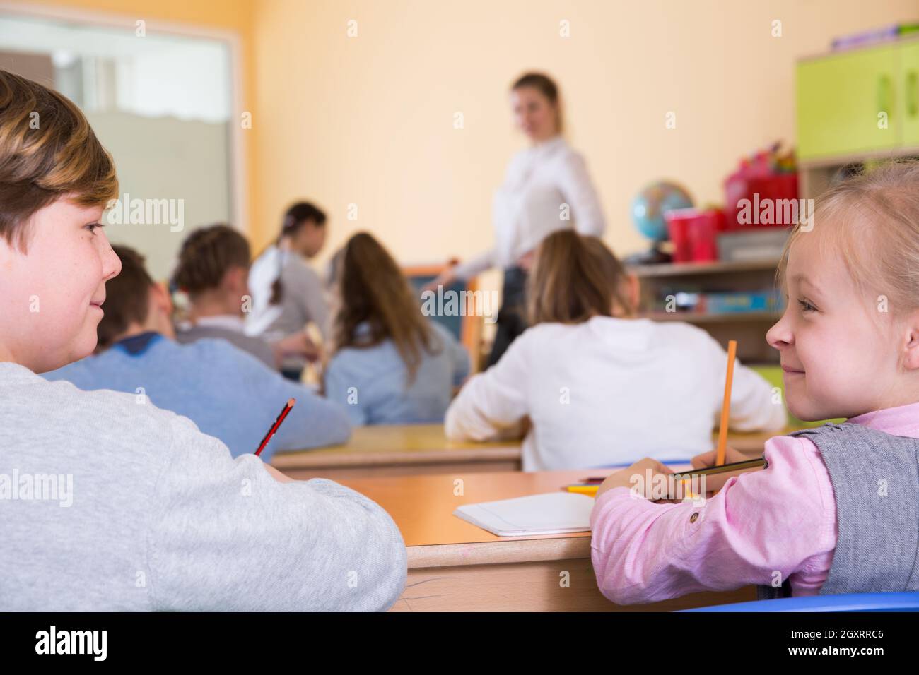 Pupils chattering at lesson Stock Photo - Alamy