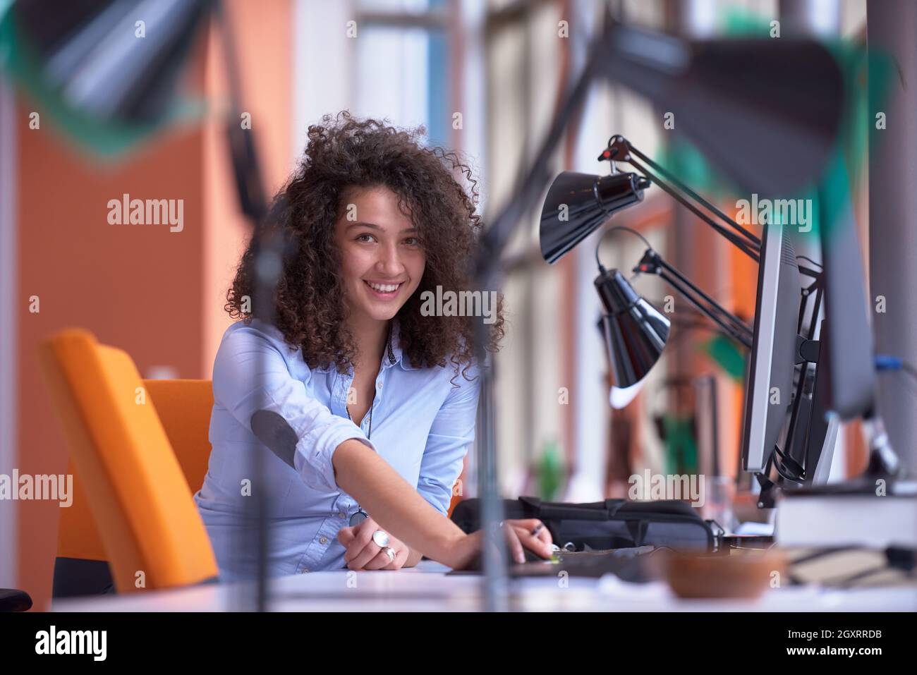 happy young business woman with curly hairstyle in the modern office ...