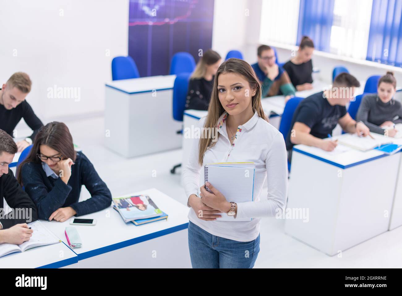 young beautiful female student with others writing notes in the ...