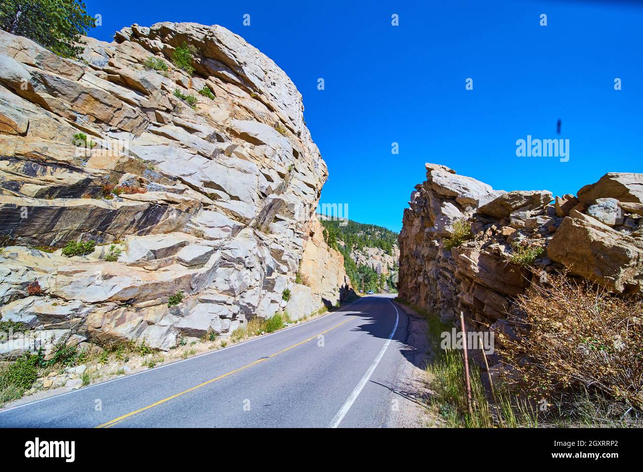 Road going through rocky mountain with large rock cliffs Stock Photo ...