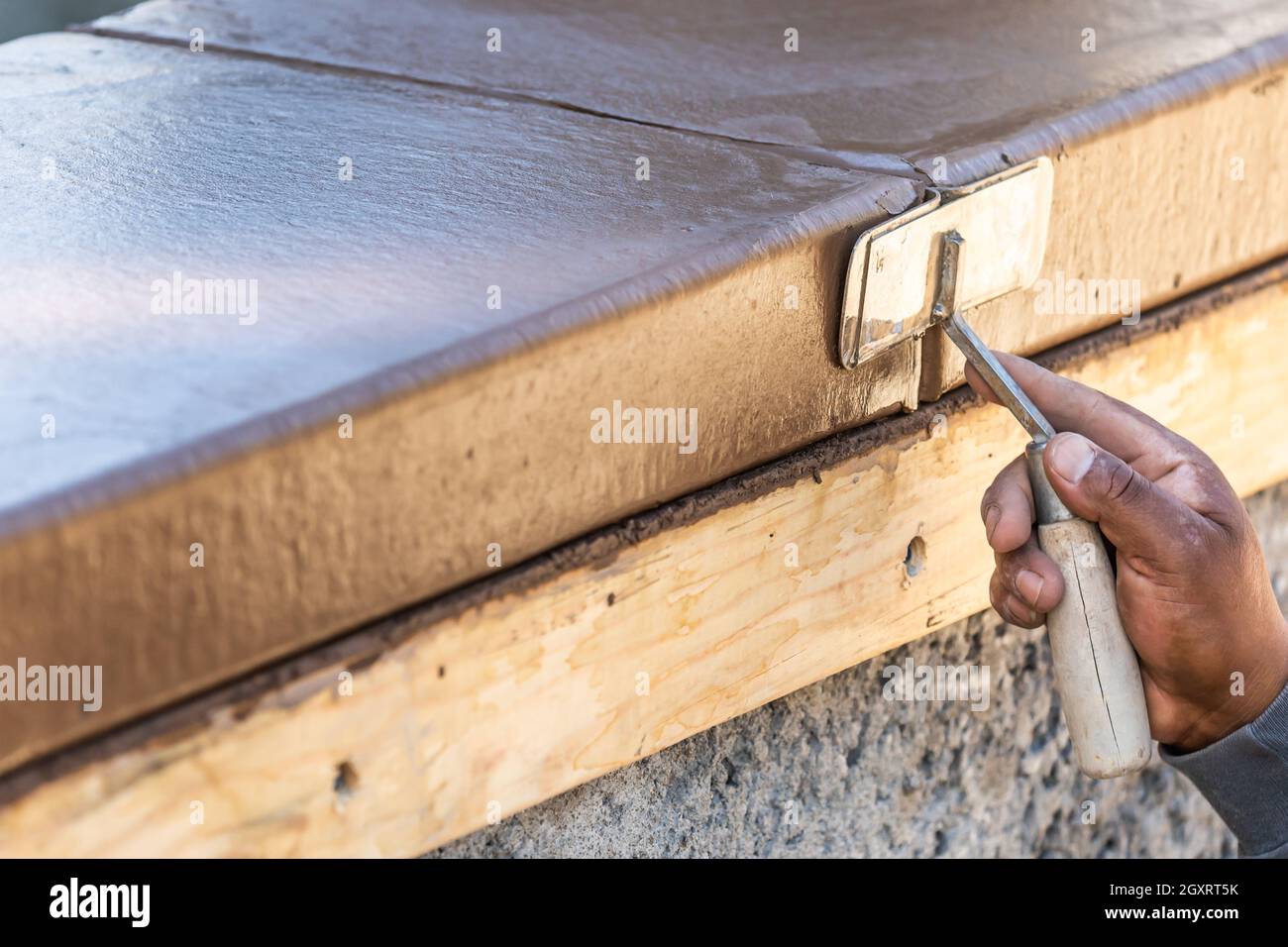 Construction Worker Using Hand Groover On Wet Cement Forming Coping ...