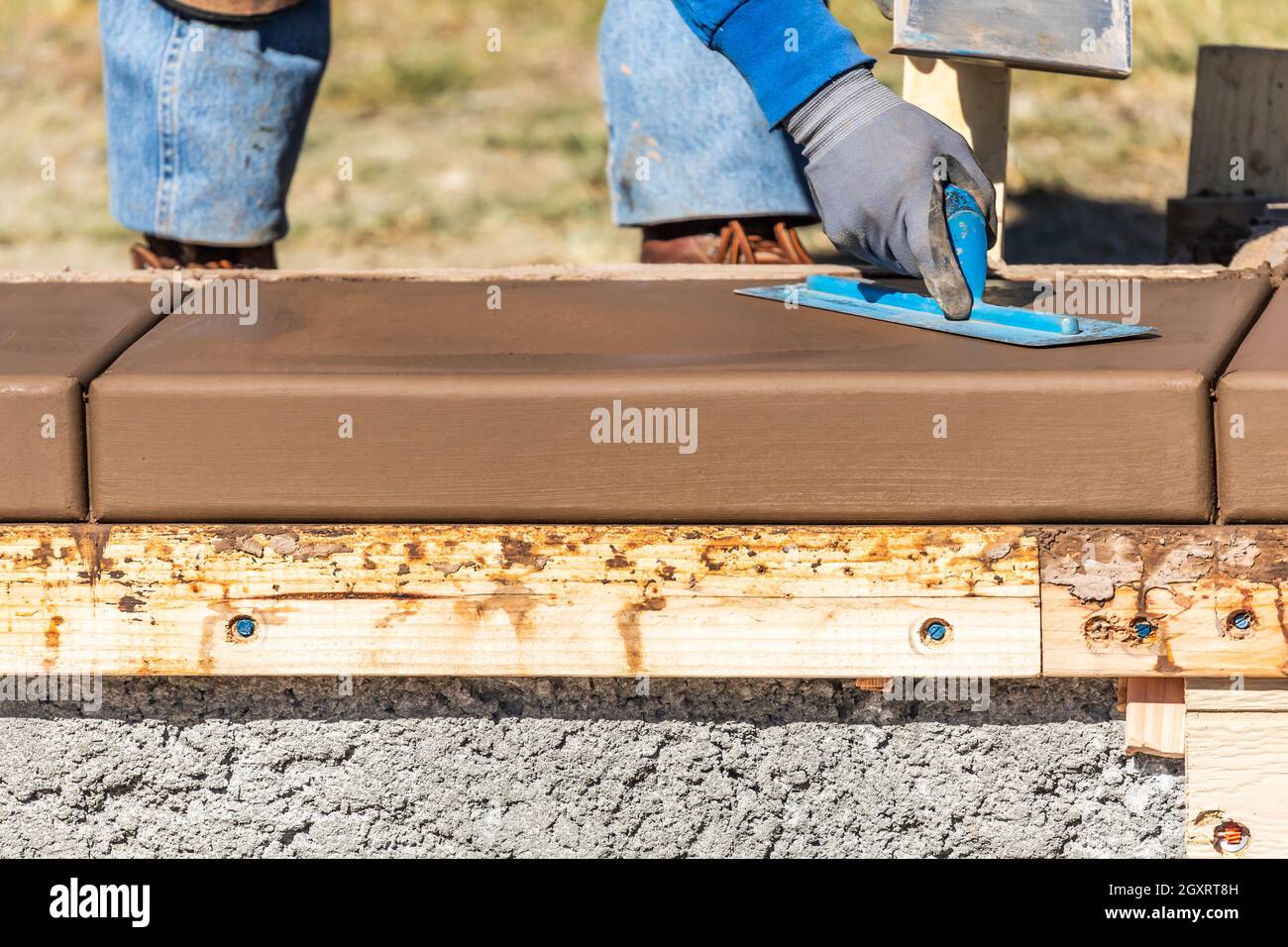 Construction Worker Using Trowel On Wet Cement Forming Coping Around ...