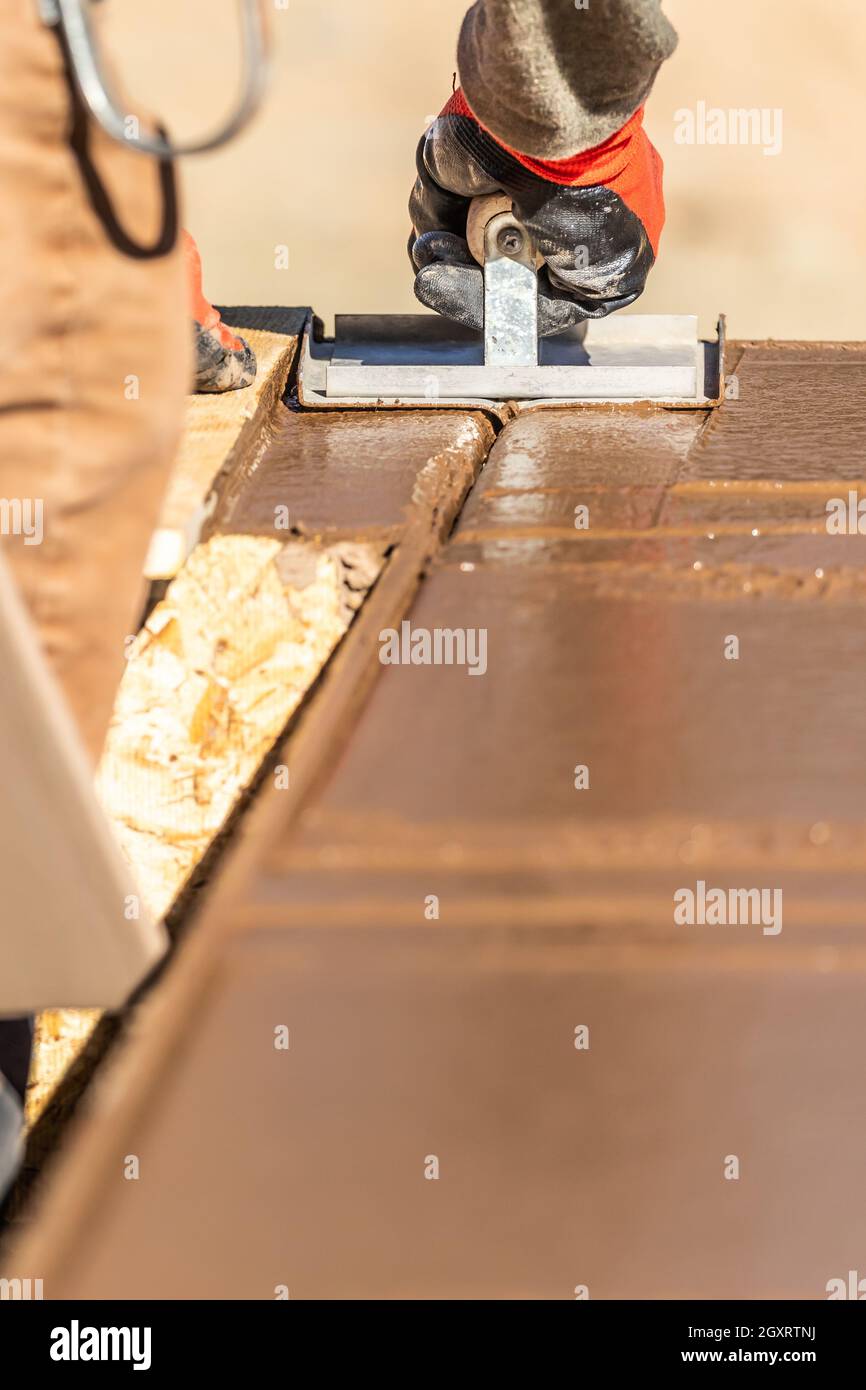 Construction Worker Using Hand Groover On Wet Cement Forming Coping ...