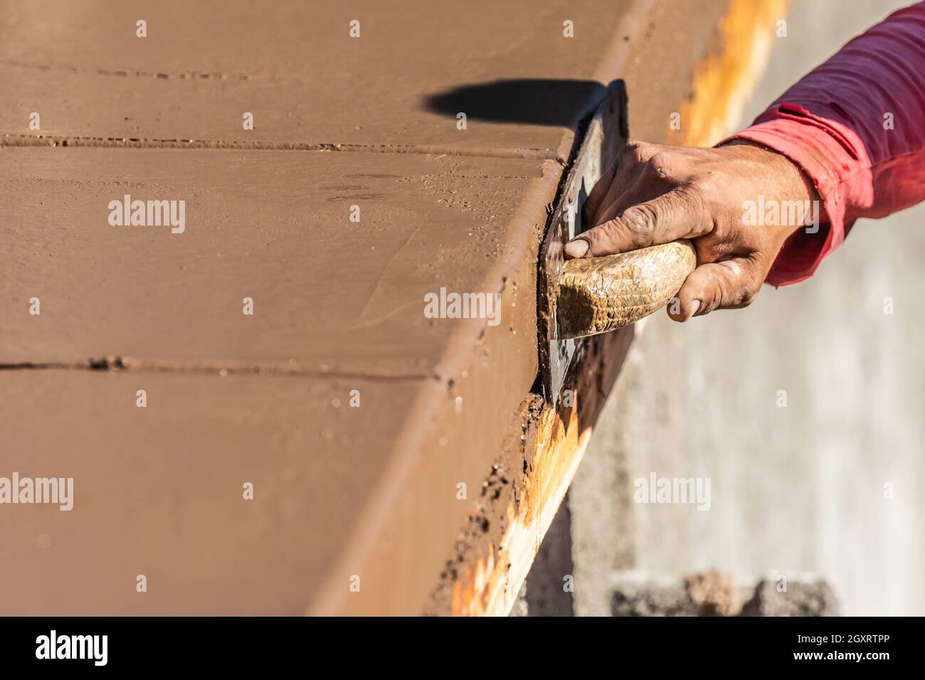 Construction Worker Using Wood Trowel On Wet Cement Forming Coping ...