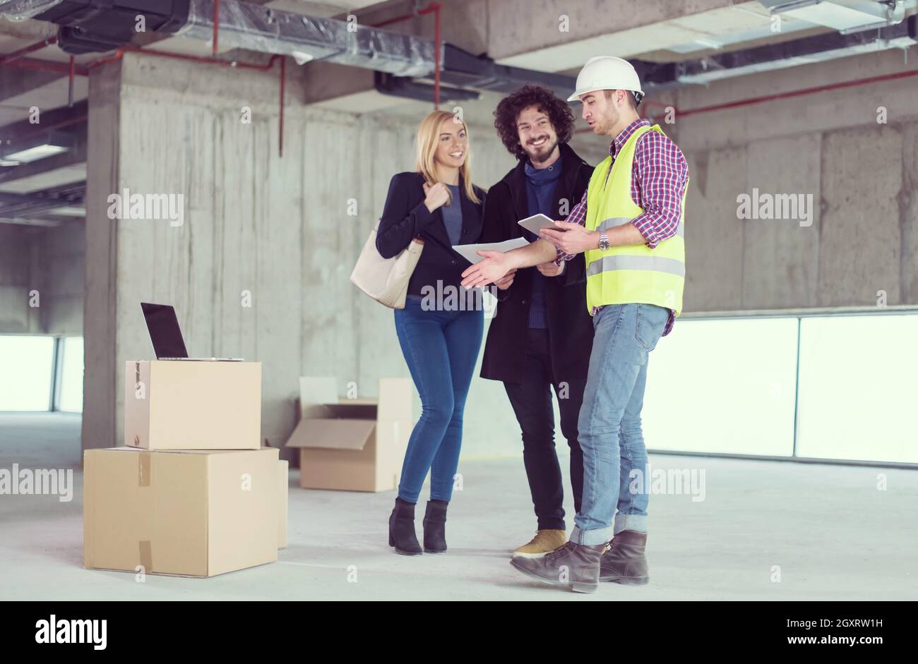 architect using tablet computer while showing house design plans to a ...