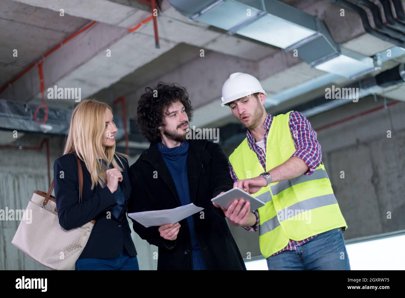 architect using tablet computer while showing house design plans to a ...