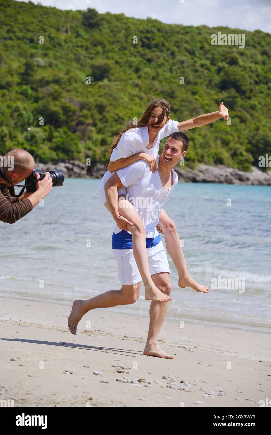 photographer taking photo of models couple on beautiful tropical beach ...