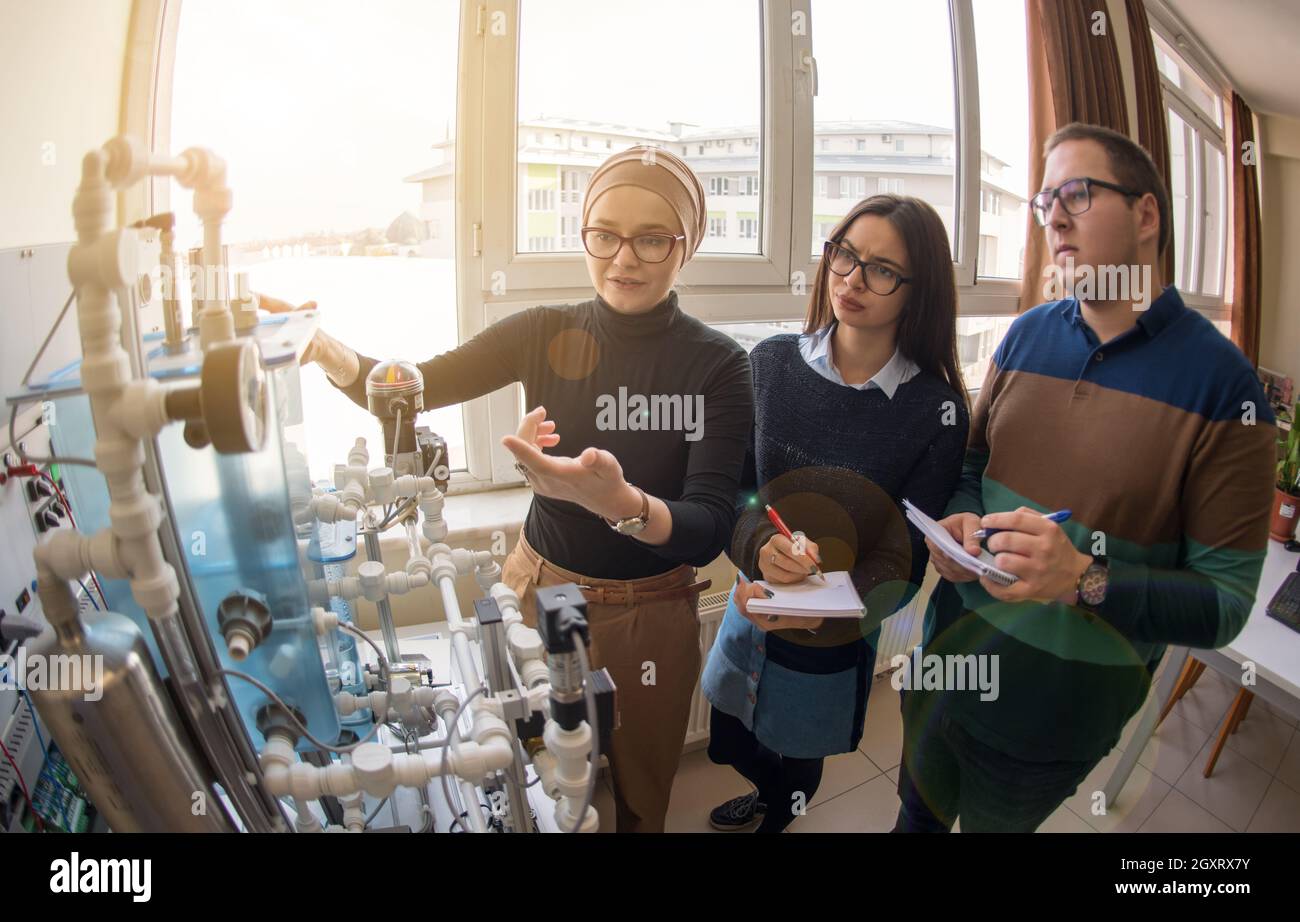 Group of students doing technical vocational practice with young female ...
