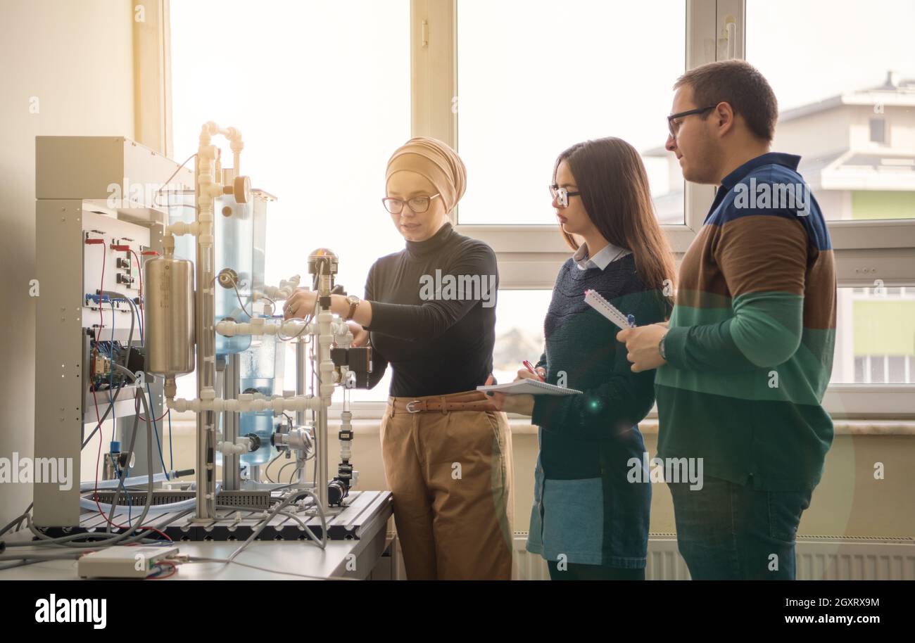 Group of students doing technical vocational practice with young female ...