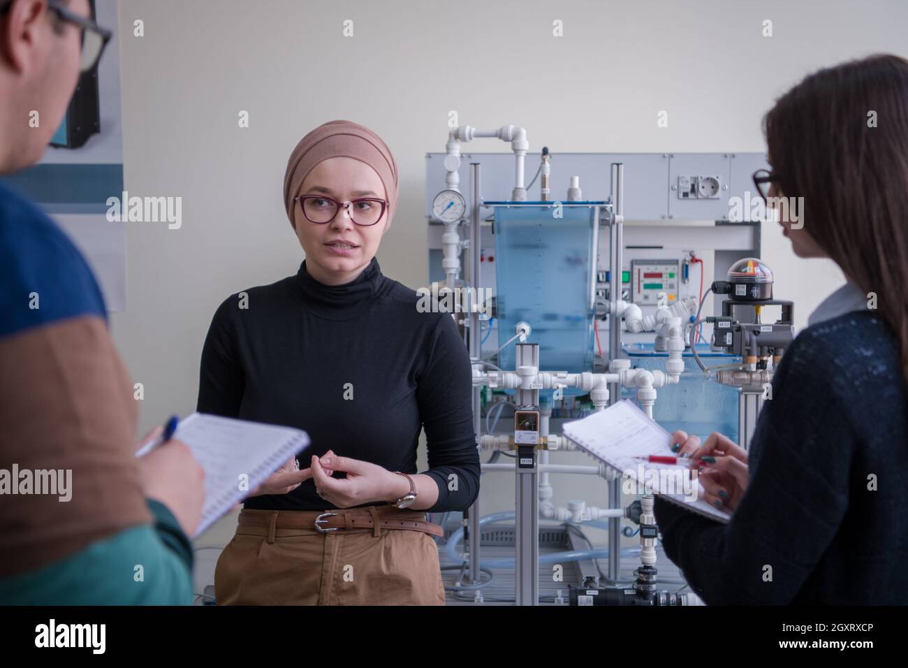 Group of students doing technical vocational practice with young female muslim teacher in the ...