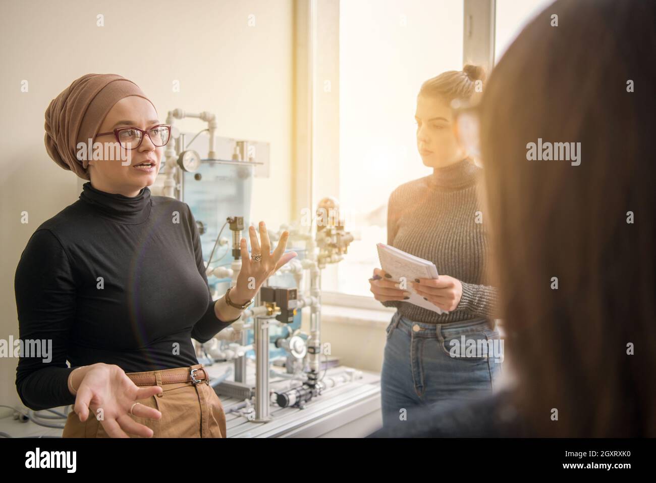 Group of students doing technical vocational practice with young female ...