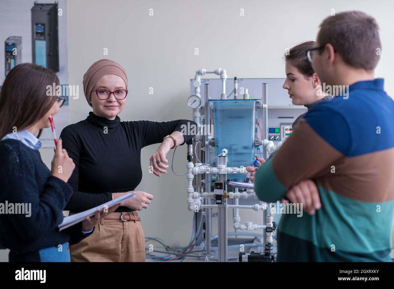 Group of students doing technical vocational practice with young female muslim teacher in the ...